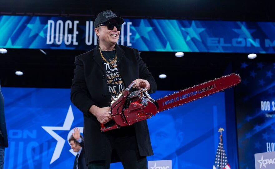 Elon Musk iese cu o drujbă pe scenă şi spune că el şi Trump se luptă cu ...